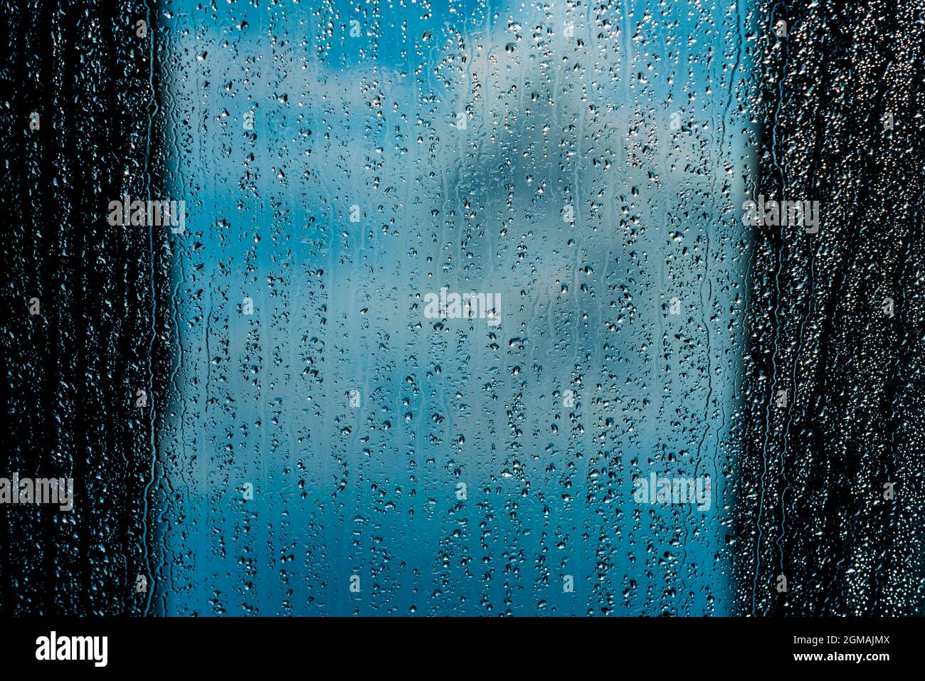 rain drops on window blue background Stock Photo - Alamy