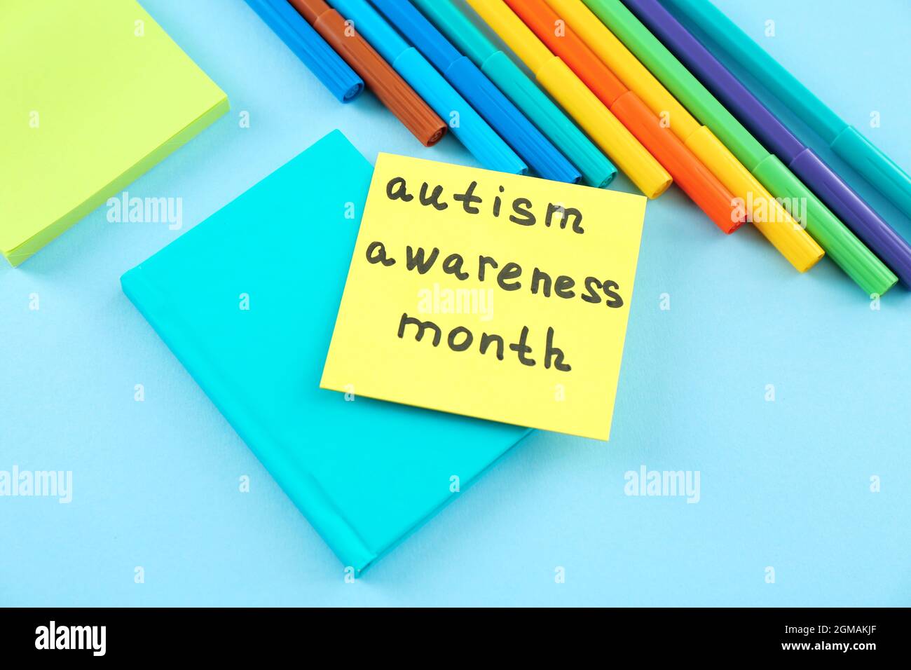 Note paper with text AUTISM AWARENESS MONTH and stationery on color ...