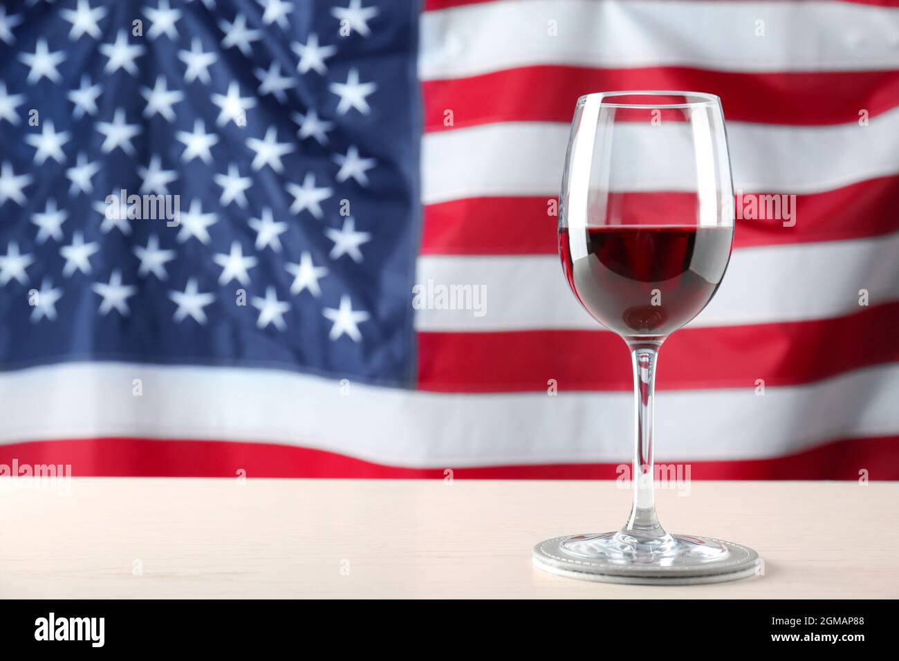 Glass of wine on table against American flag background Stock Photo - Alamy