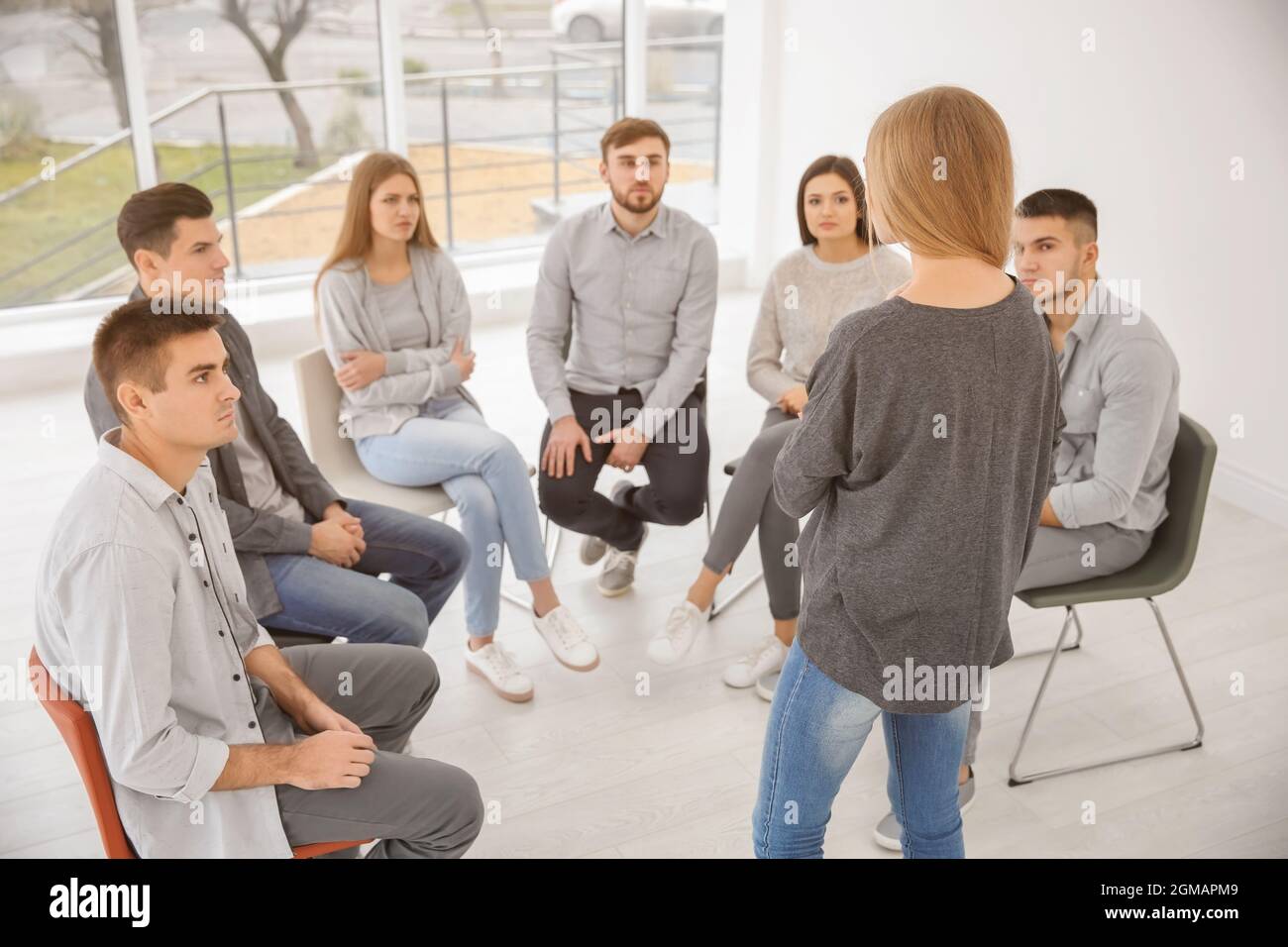 Young woman talking about her feelings during group therapy, indoors ...