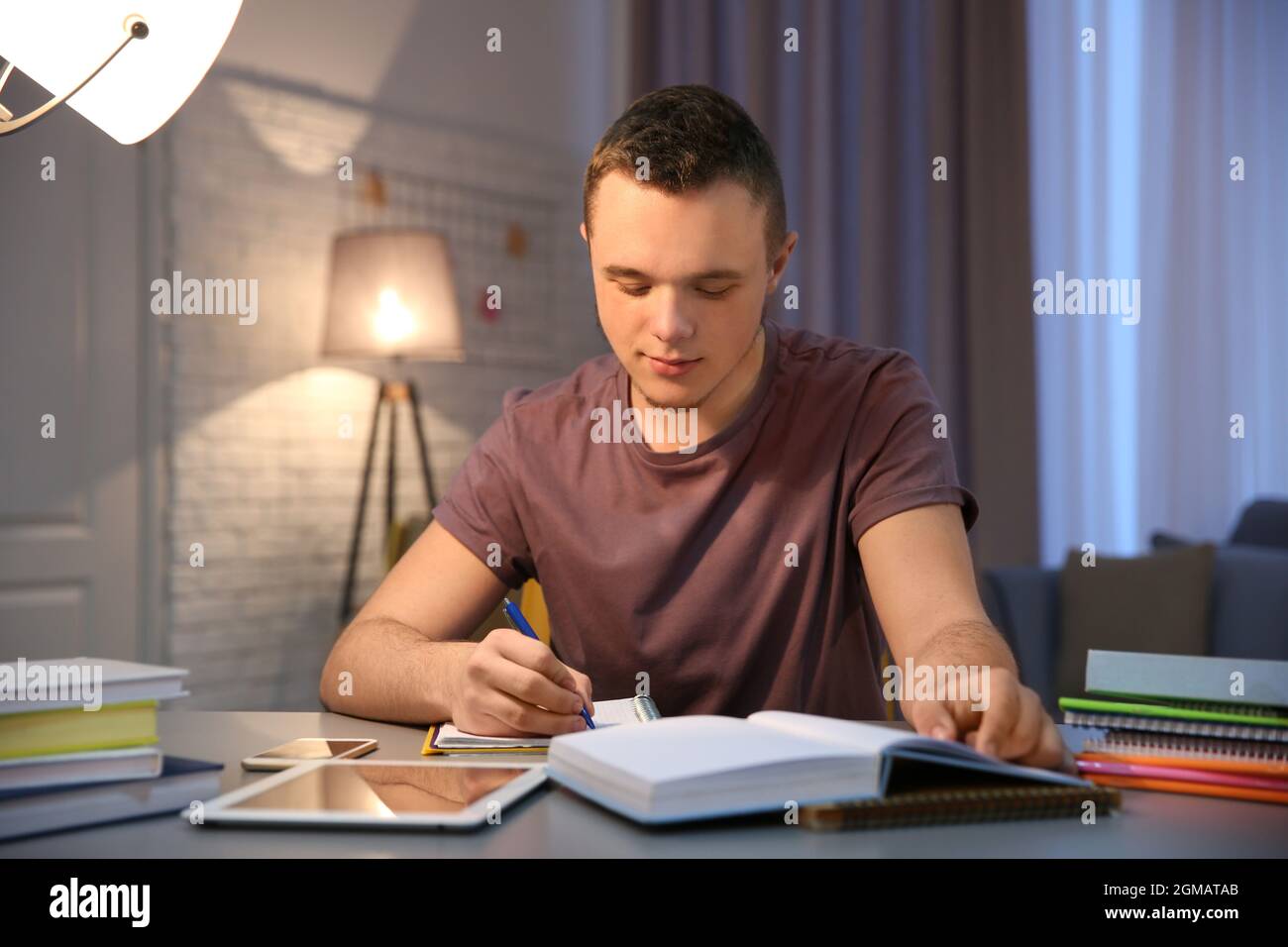 Student doing homework indoors late at night Stock Photo - Alamy