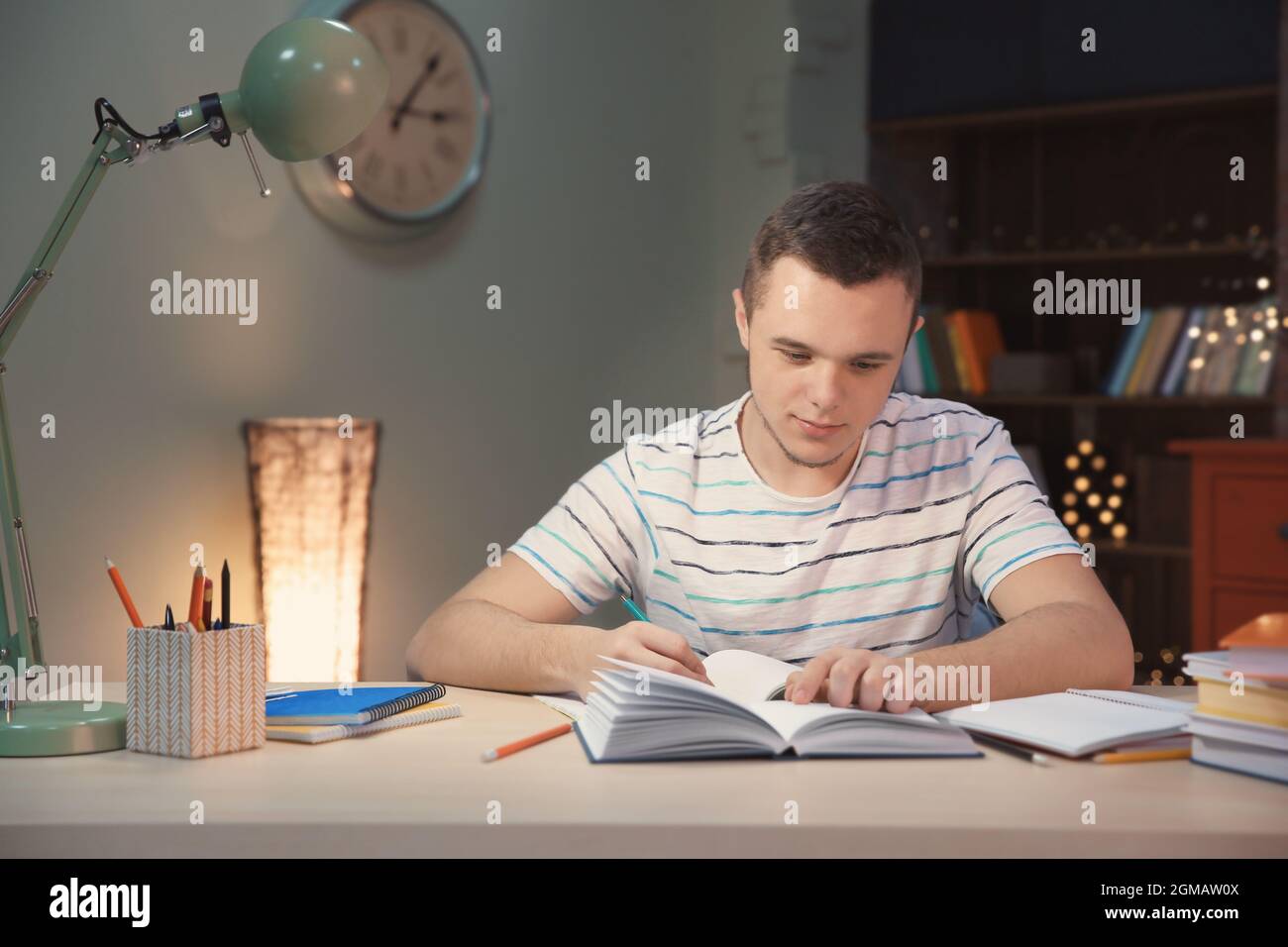 Student doing homework indoors late at night Stock Photo - Alamy