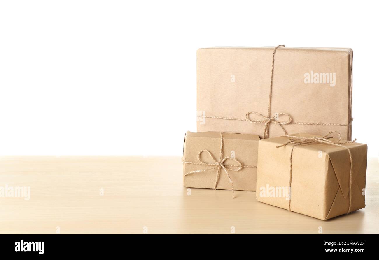 Parcel gift boxes on table against white background Stock Photo - Alamy