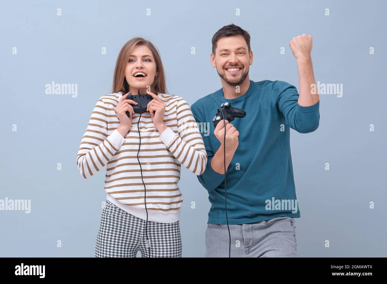 Emotional couple with video game controllers on color background Stock ...