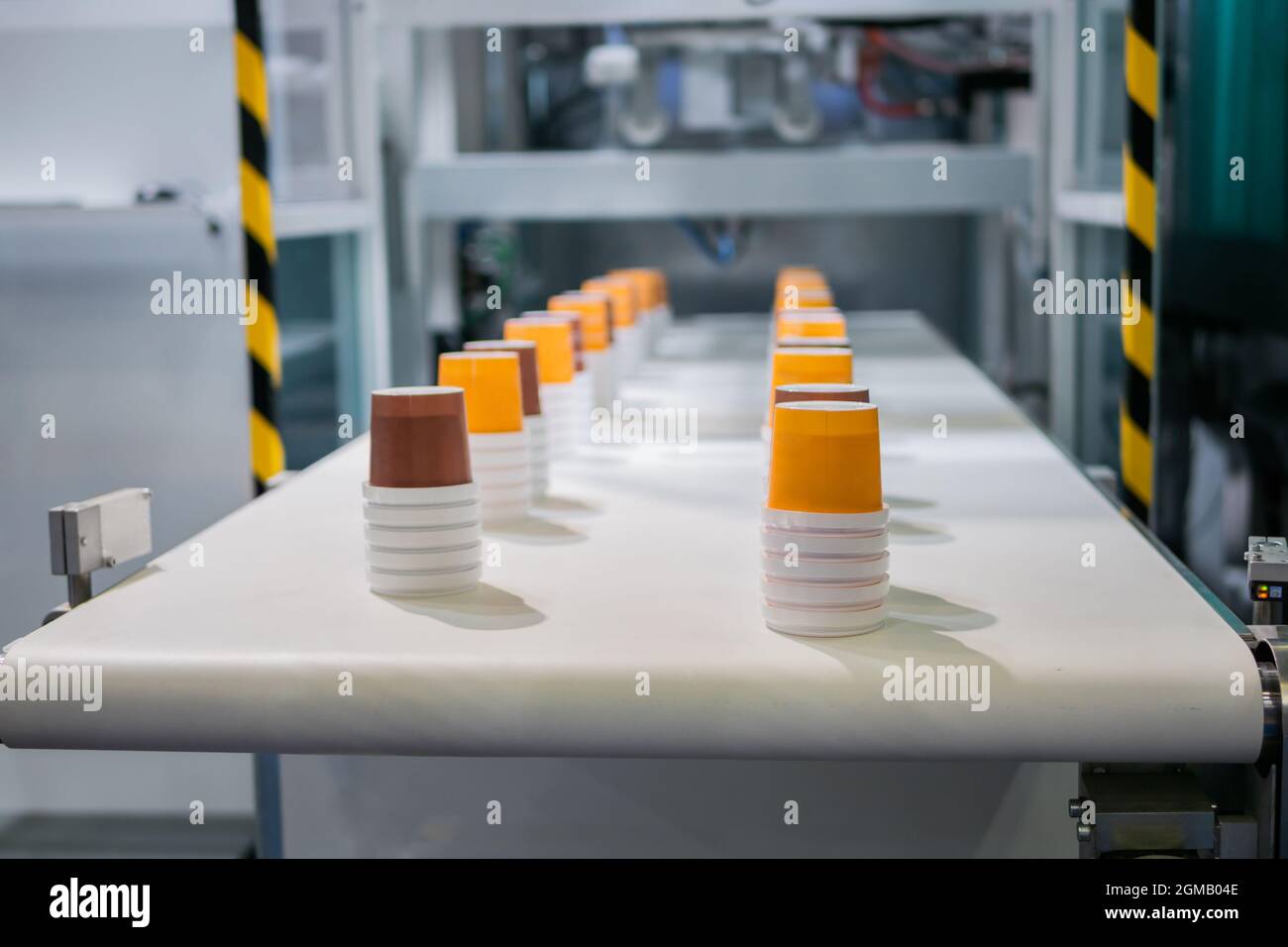 Empty plastic cups moving on conveyor belt at package exhibition Stock ...
