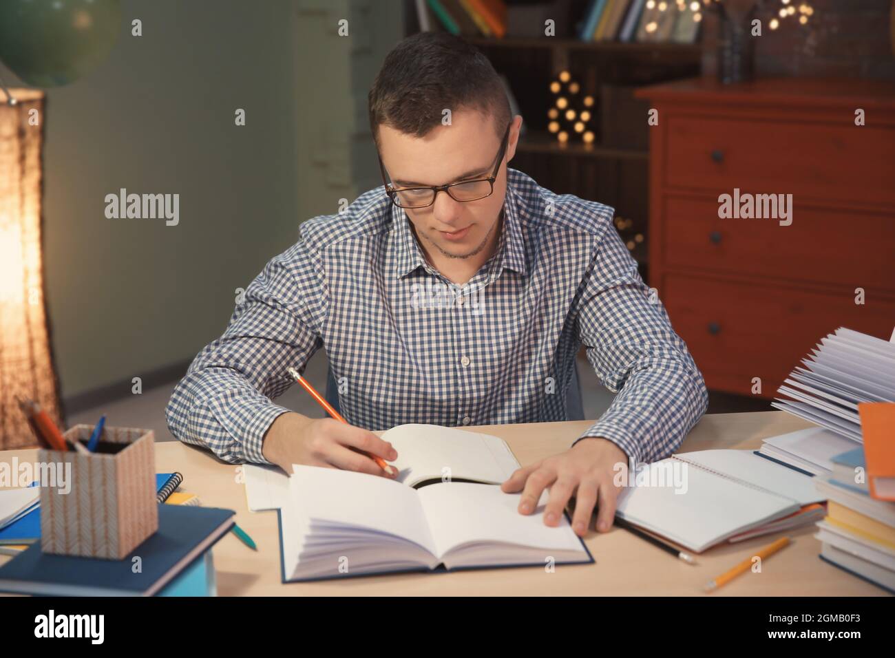 Student doing homework indoors late at night Stock Photo - Alamy