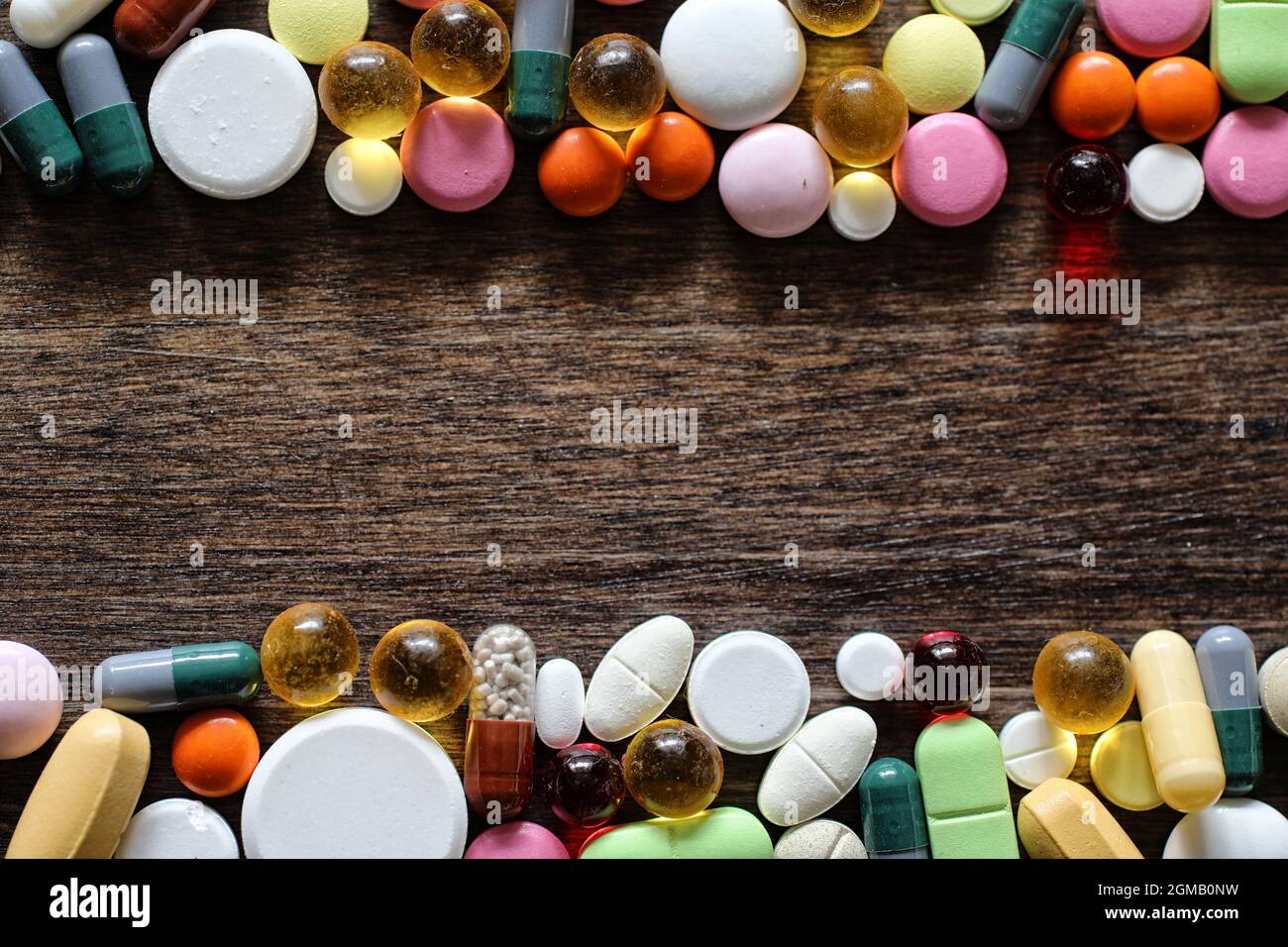 Medical background of various colorful medications on a textured wooden ...