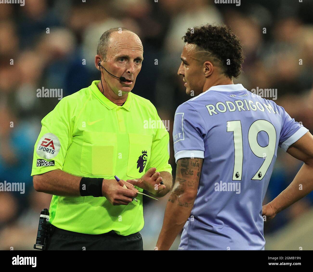 Referee Mike Dean gives Rodrigo Moreno #19 of Leeds United a yellow ...