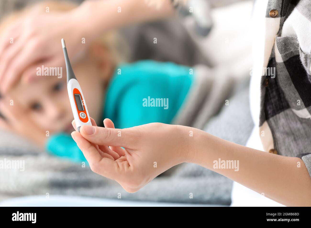 Mother measuring temperature of her sick daughter at home Stock Photo - Alamy