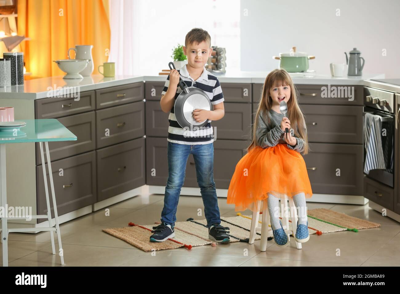 Cute little children playing as musical band in kitchen Stock Photo - Alamy