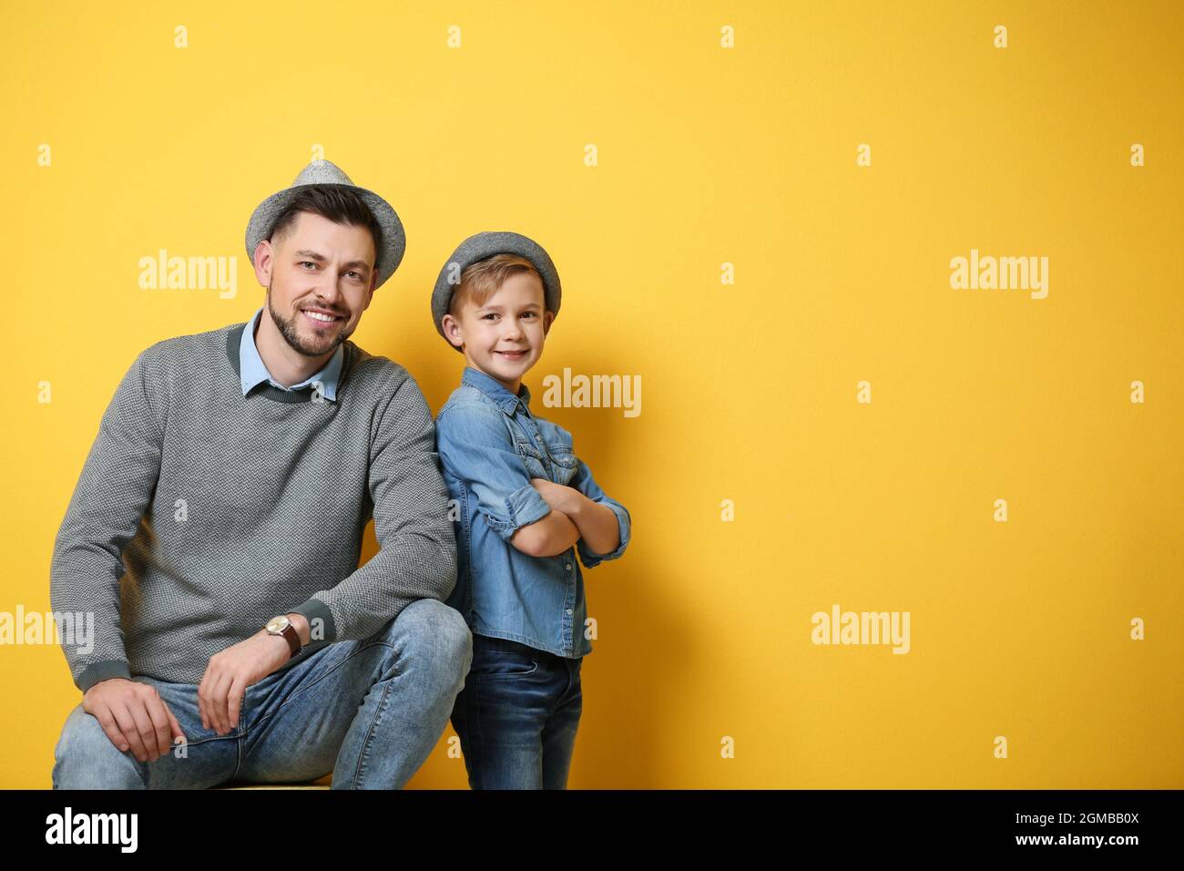 Stylish father and son on color background Stock Photo - Alamy