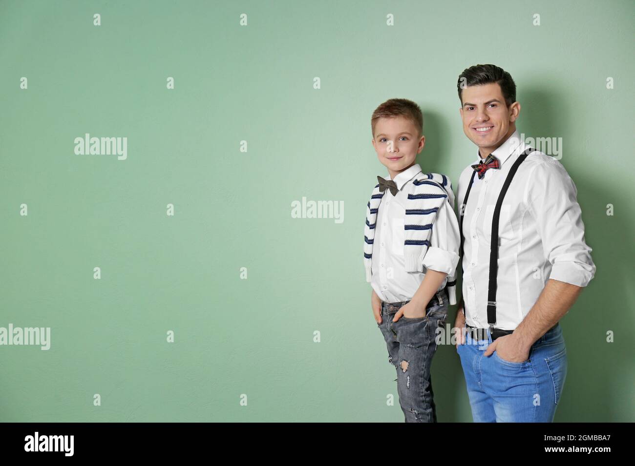 Stylish father and son on color background Stock Photo - Alamy