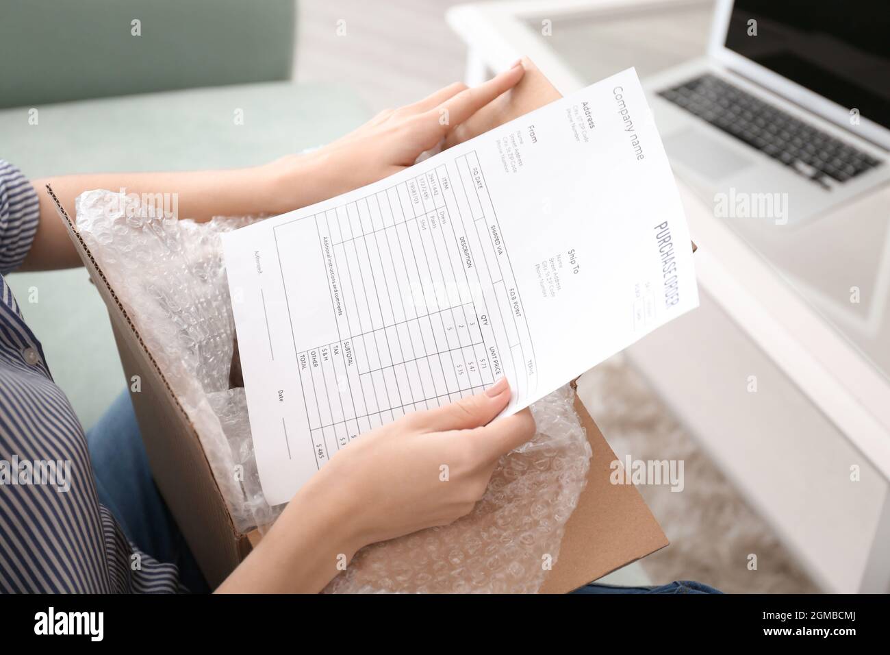 Young woman with purchase order sheet for parcel at home Stock Photo ...