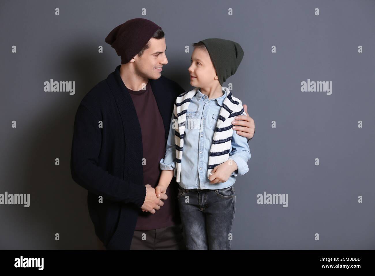 Stylish father and son on gray background Stock Photo - Alamy