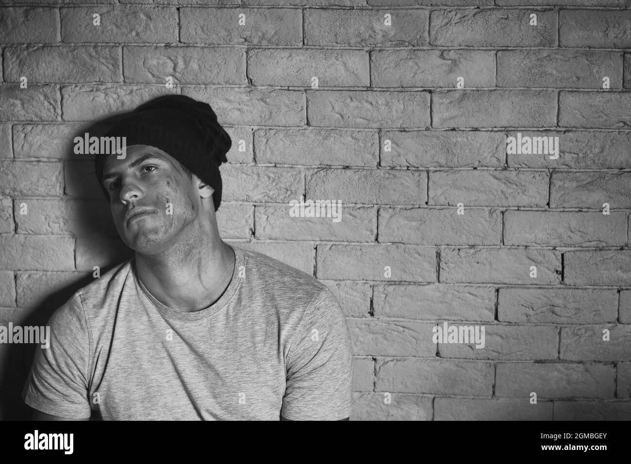 Homeless poor man near brick wall Stock Photo - Alamy