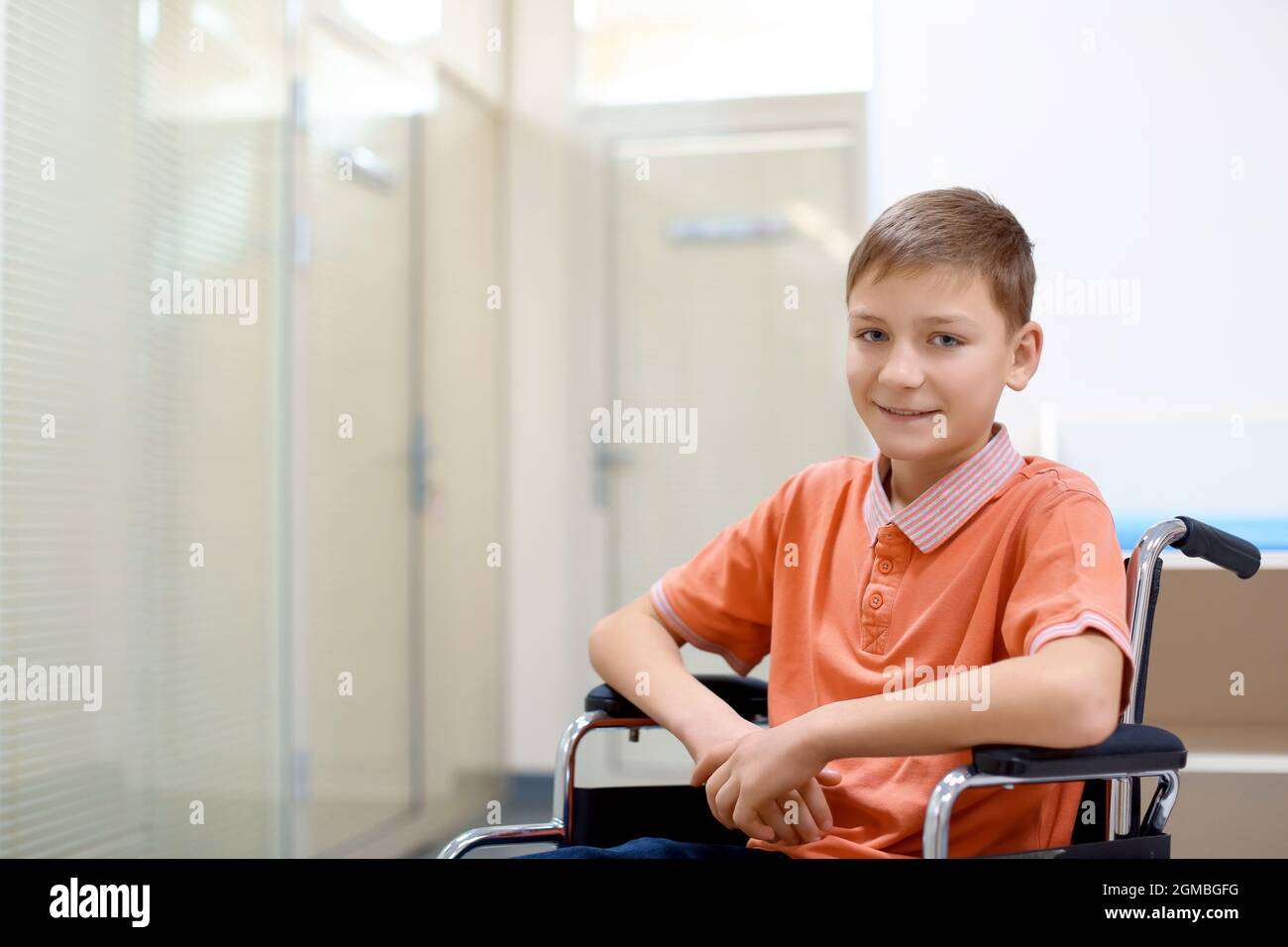 Little boy sitting in wheelchair indoors Stock Photo - Alamy