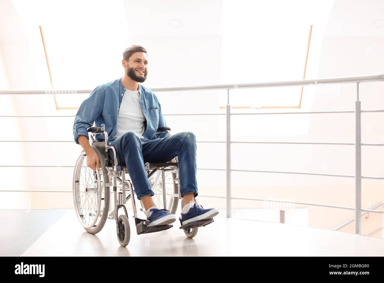 Man sitting in wheelchair indoors Stock Photo - Alamy