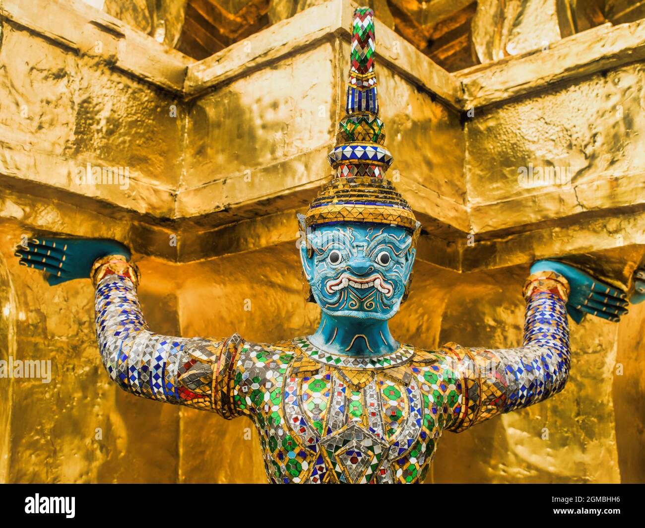 Statue of the demon guardian lifting golden pagoda in the Temple of the ...