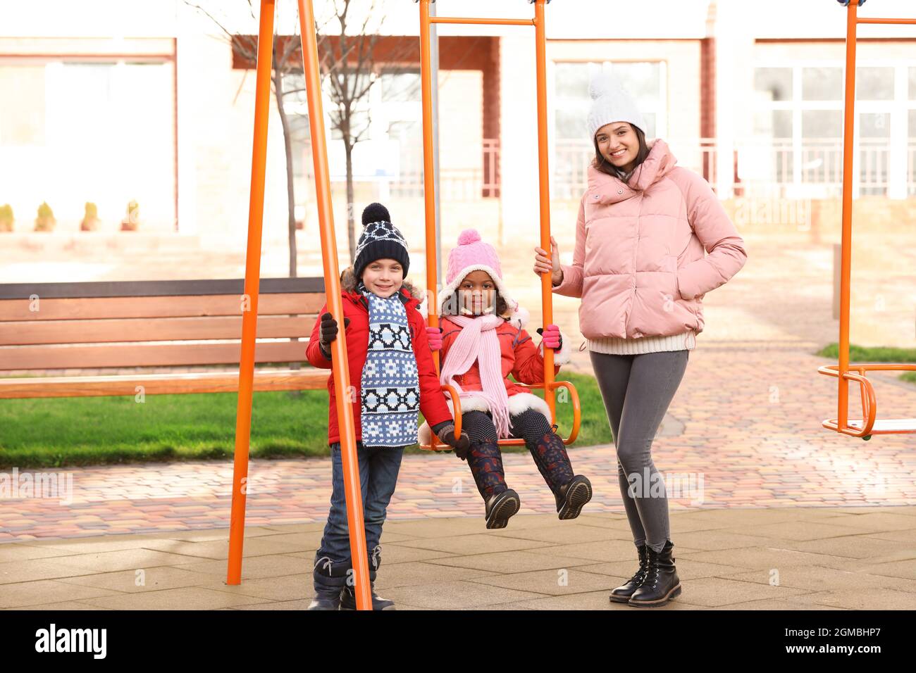Young woman with little kids on playground. Child adoption Stock Photo ...