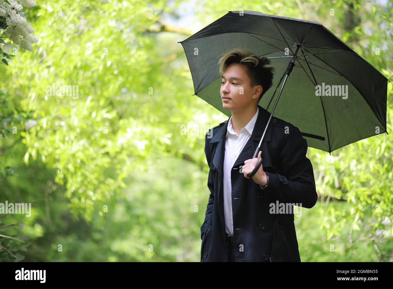 Spring Park in rainy weather and a young man with an umbrella Stock ...