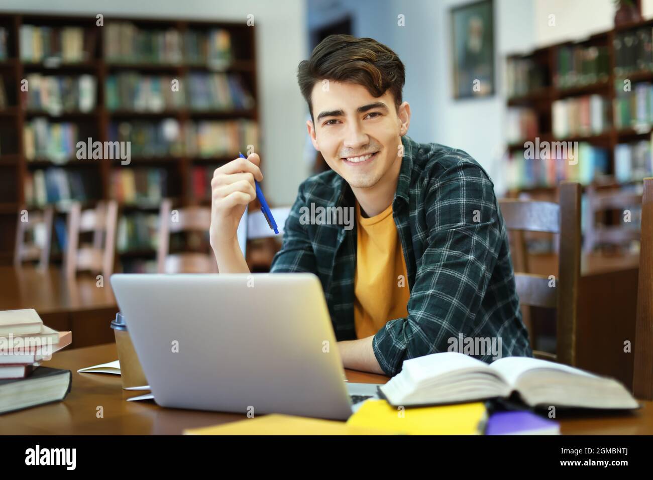 Student with laptop studying in library Stock Photo - Alamy