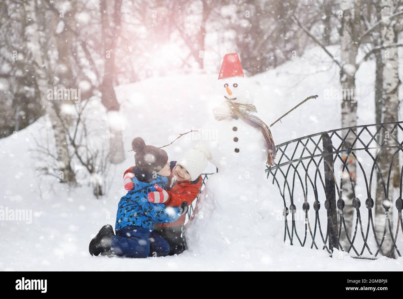 Children in the park in winter. Kids play with snow on the playground ...