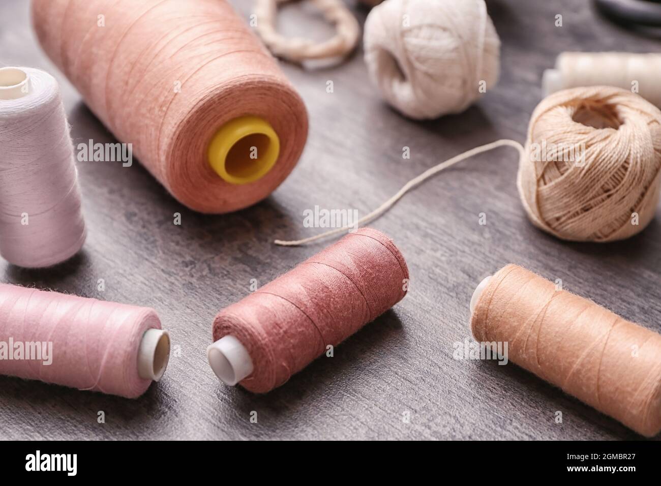 Sewing threads with clews on grey background Stock Photo - Alamy