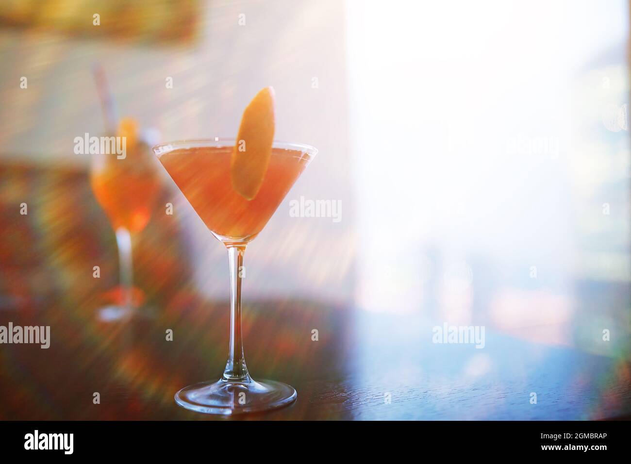 Cocktail glasses on the windowsill by the glass of a tall building ...