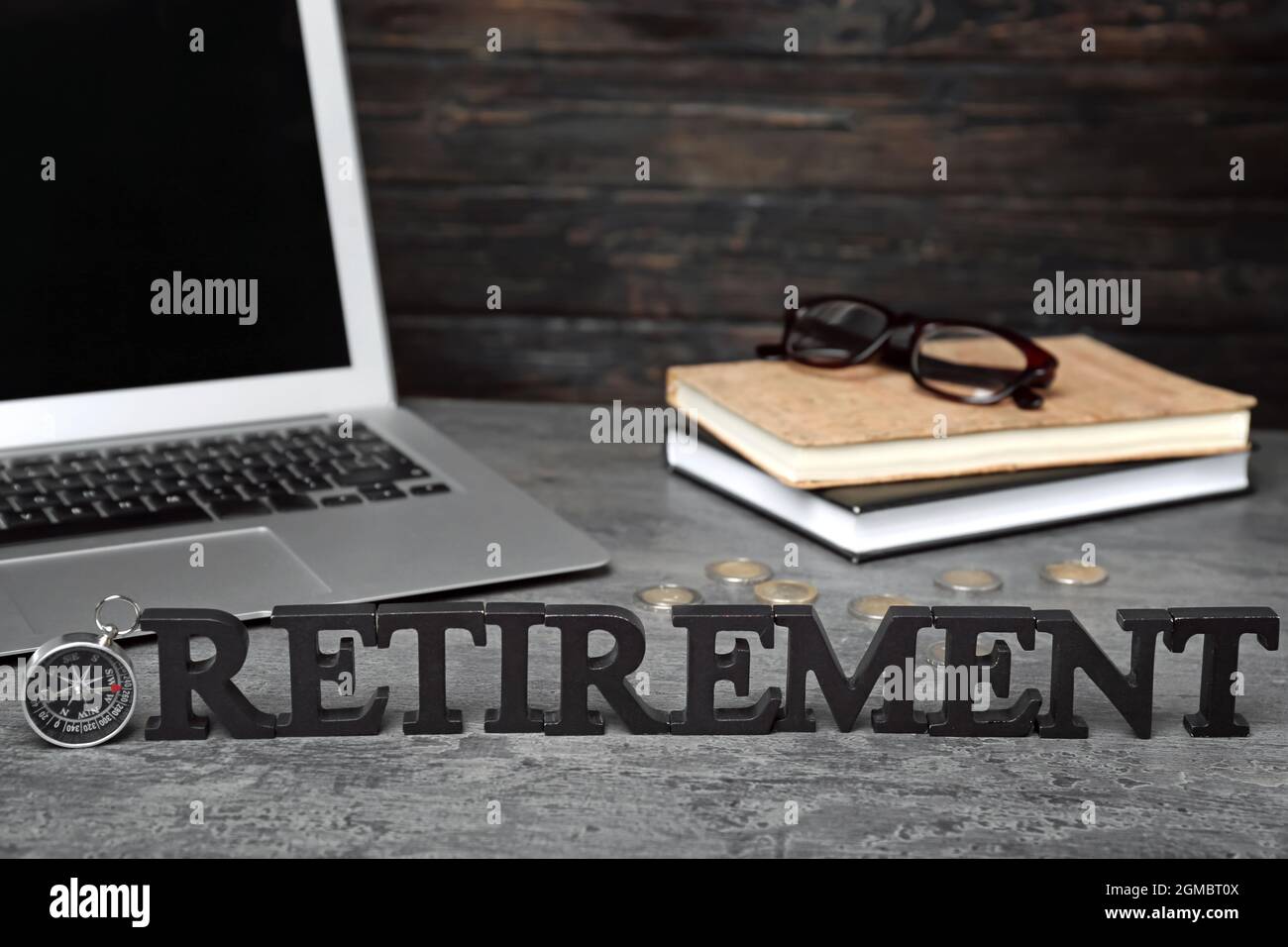 Word RETIREMENT, compass and laptop on grey table. Pension planning ...
