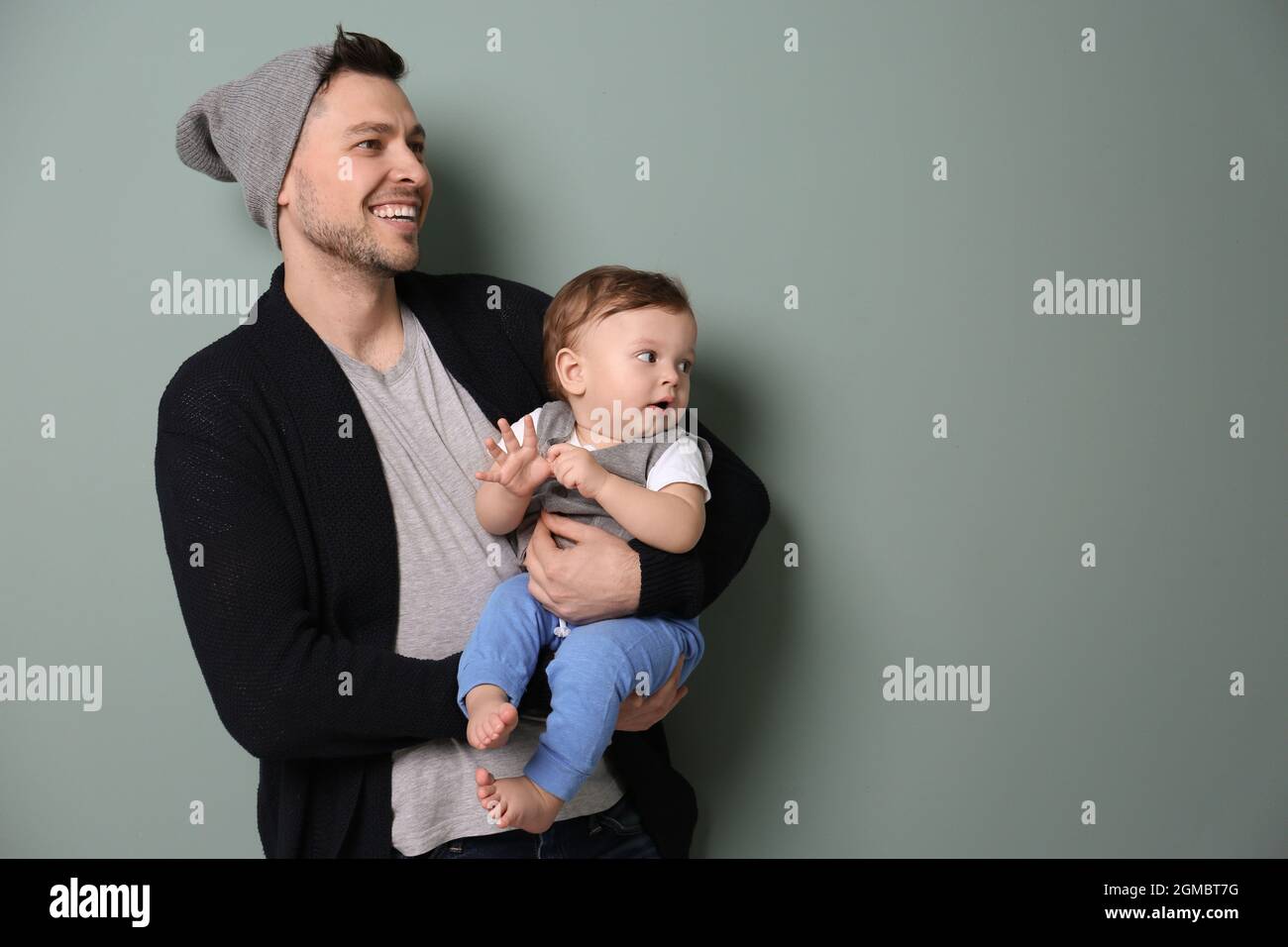 Handsome stylish dad with his little son against grey background Stock ...
