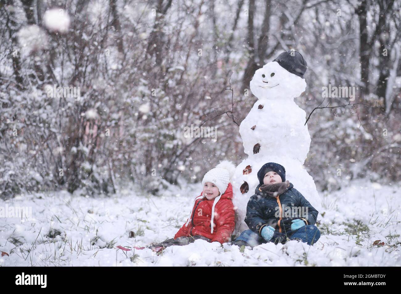 Kids walk in the park with first snow Stock Photo - Alamy