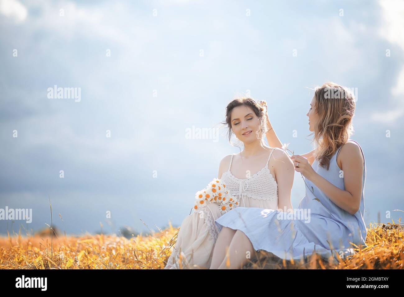 Two beautiful girls in dresses in autumn field have fun Stock Photo - Alamy