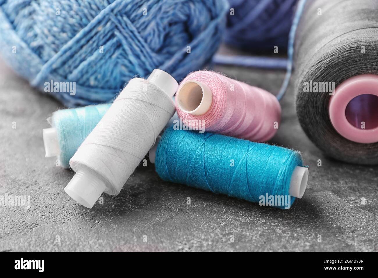 Colorful threads on grey background Stock Photo - Alamy
