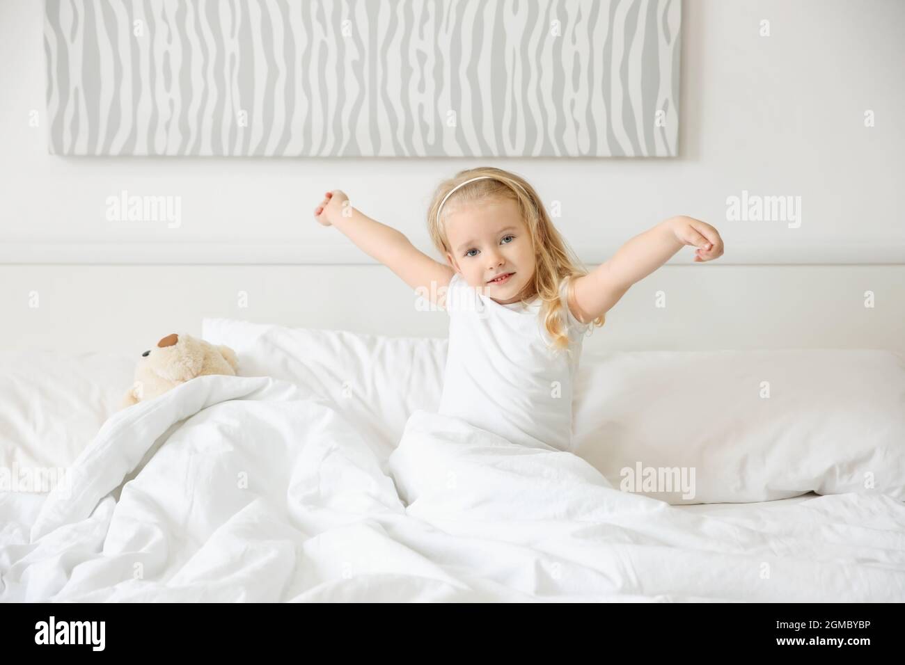 Cute little girl stretching in bed at home Stock Photo - Alamy