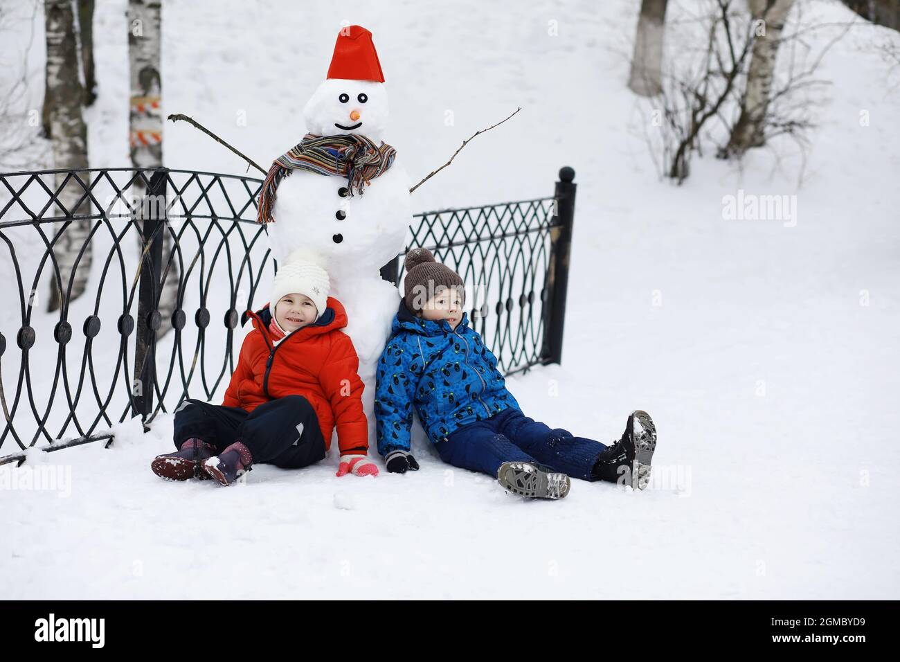 Children in the park in winter. Kids play with snow on the playground ...