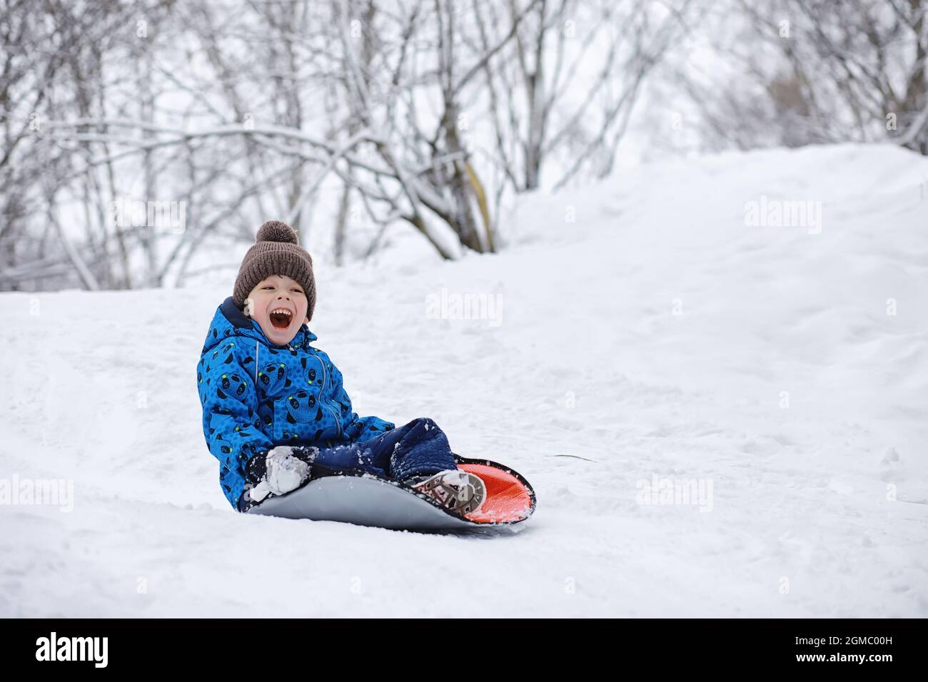 Children in the park in winter. Kids play with snow on playground. They ...