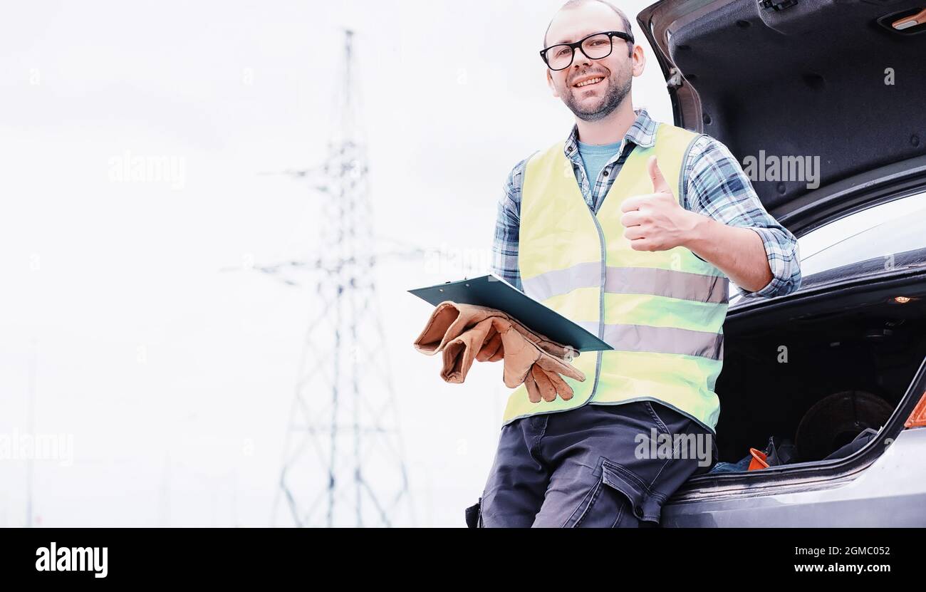 A man in a helmet and uniform, an electrician in the field ...