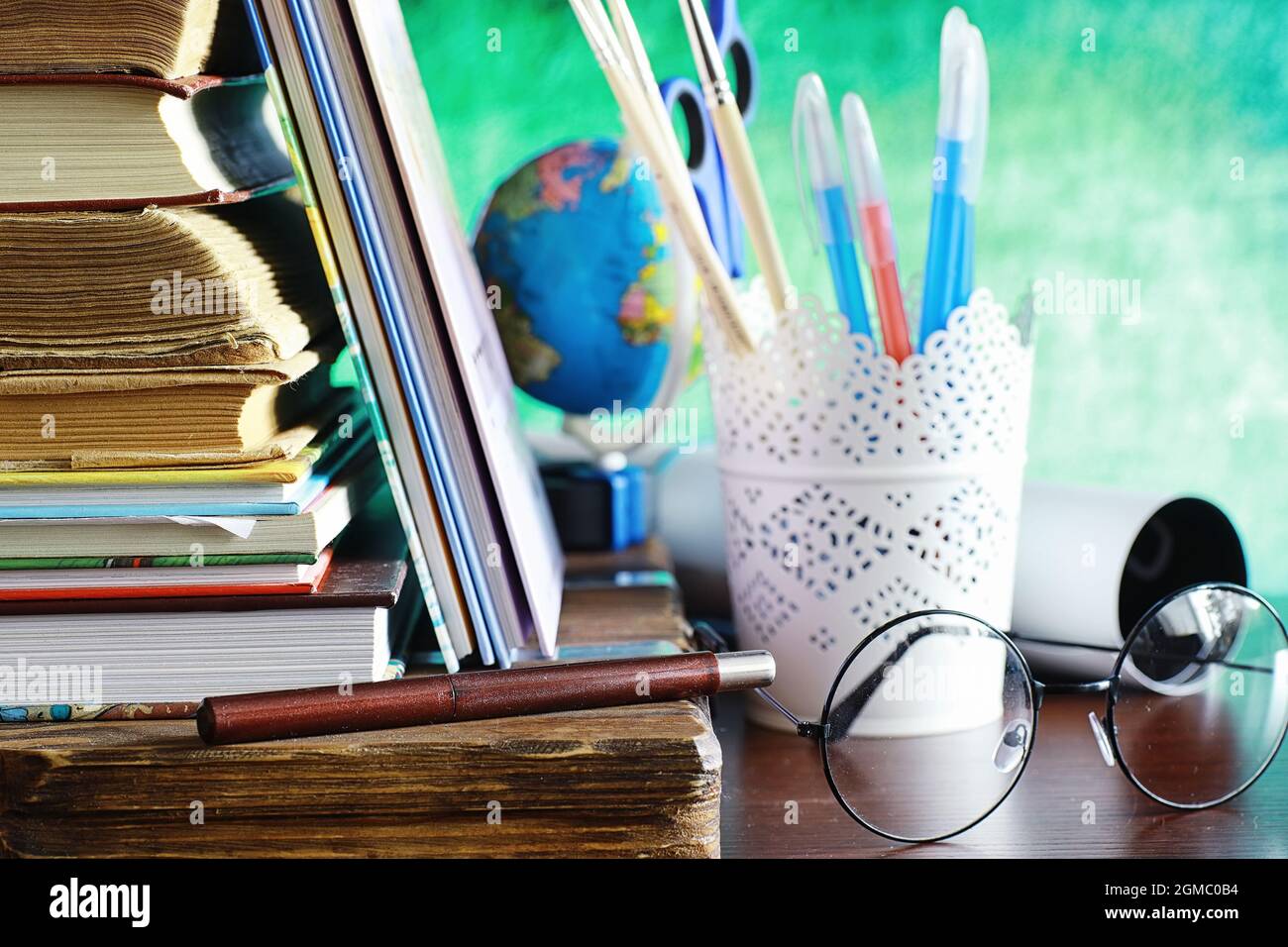 Education concept. A stack of textbooks and a book on the desk with ...
