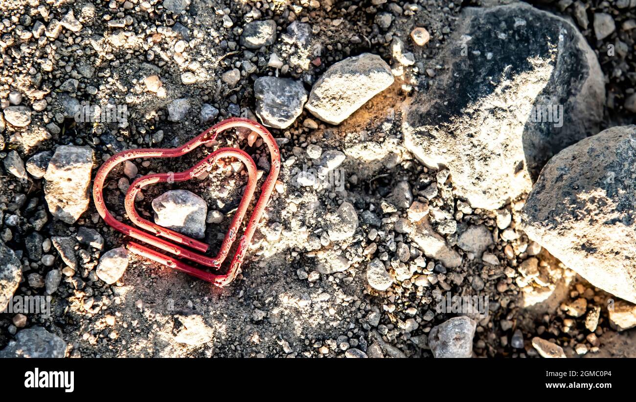 Broken Paper Clip lying on the dirty lane. Symbol photo for getting ...