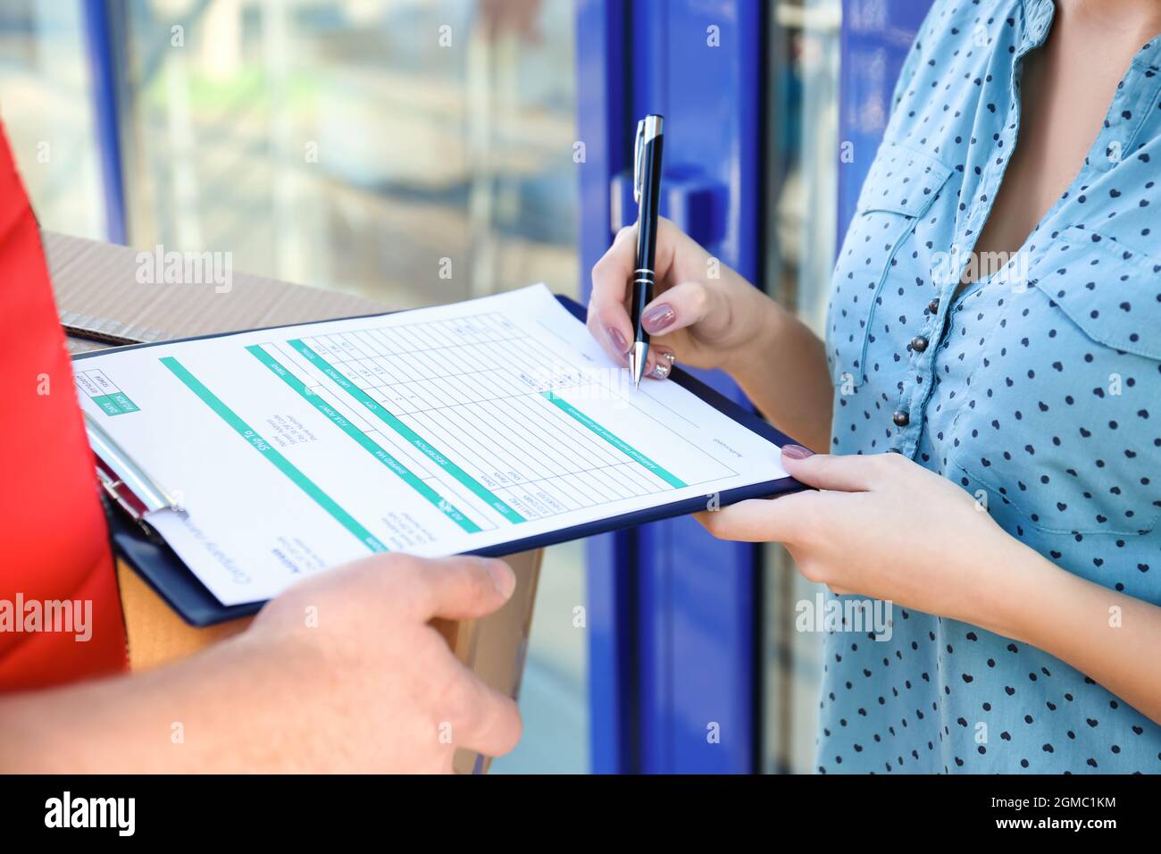 Woman signing for parcel delivery, closeup Stock Photo - Alamy