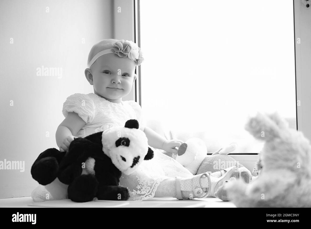 Child in the children's room. The kid is sitting on the windowsill at ...