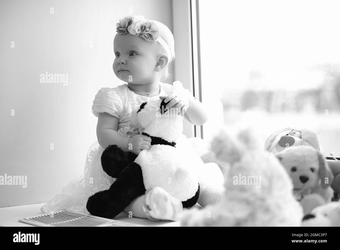 Child in the children's room. The kid is sitting on the windowsill at ...