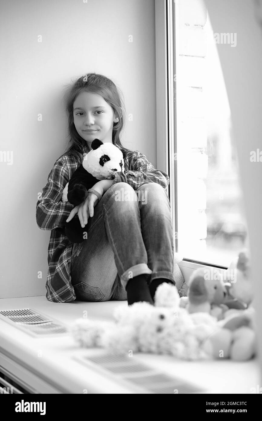 Child in the children's room. The kid is sitting on the windowsill at ...