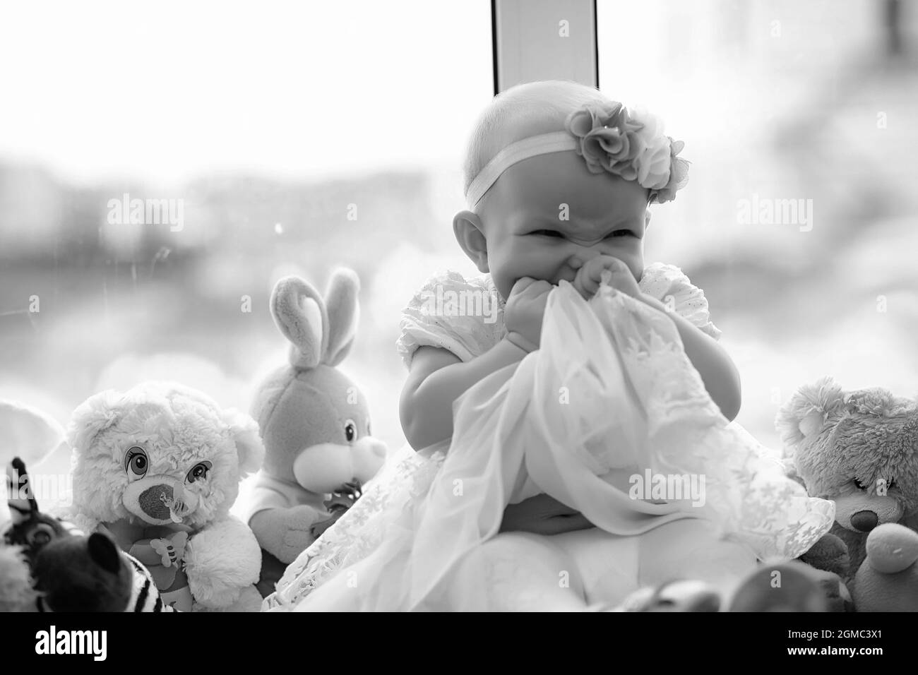 Child in the children's room. The kid is sitting on the windowsill at ...
