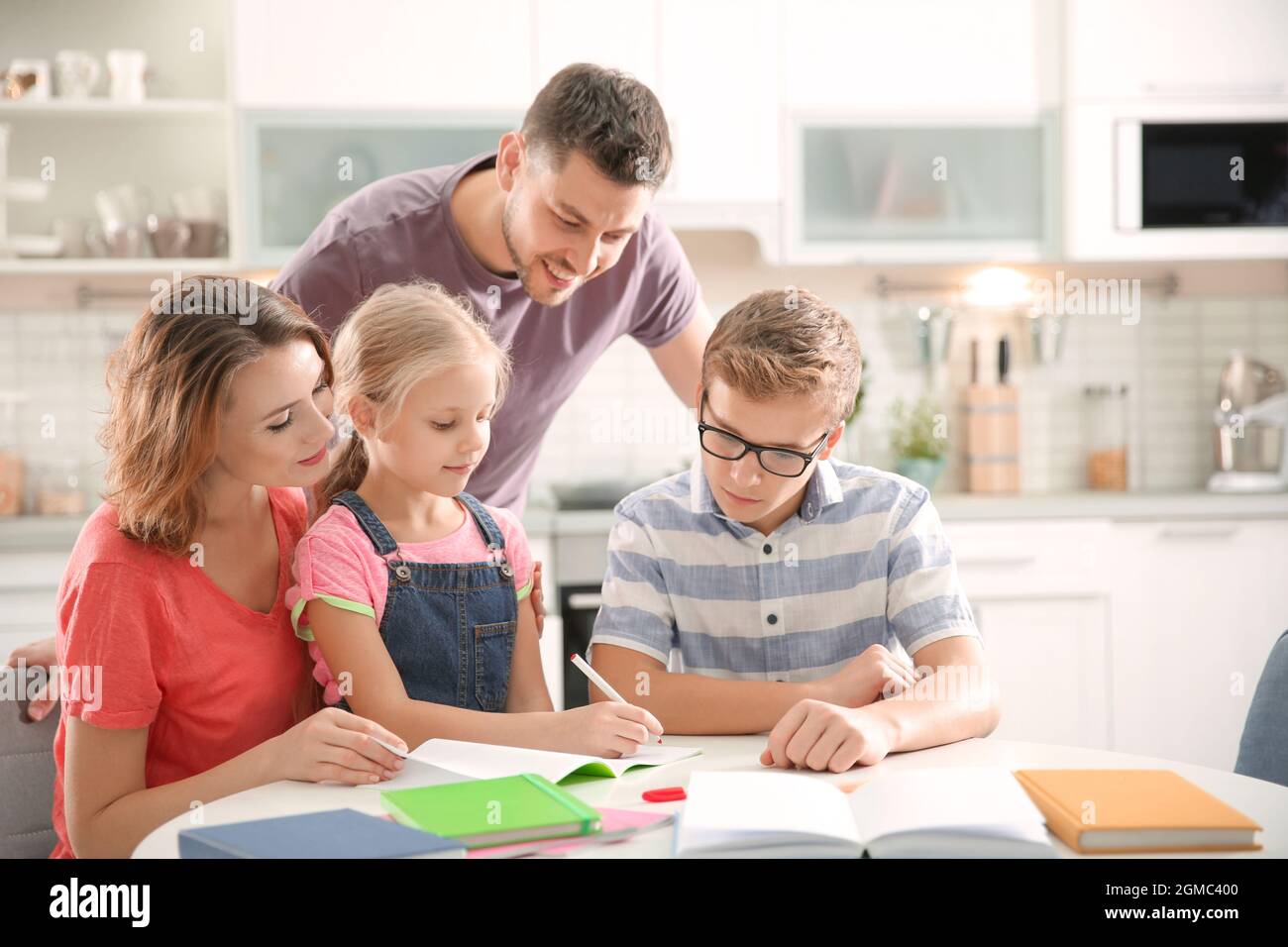 Children with parents doing homework at home Stock Photo - Alamy