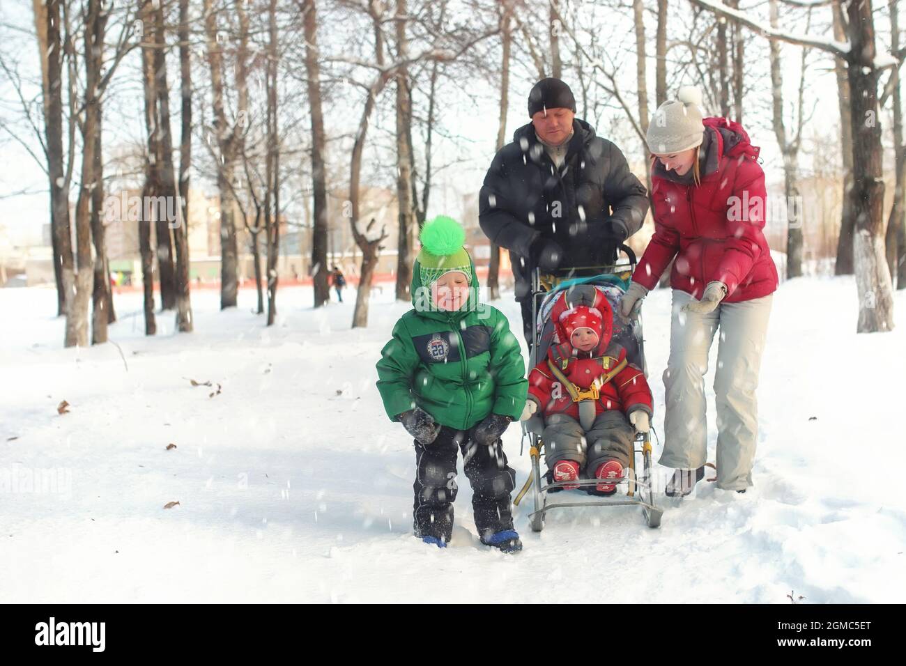 Family with children in the park in winter snow blizzard Stock Photo ...