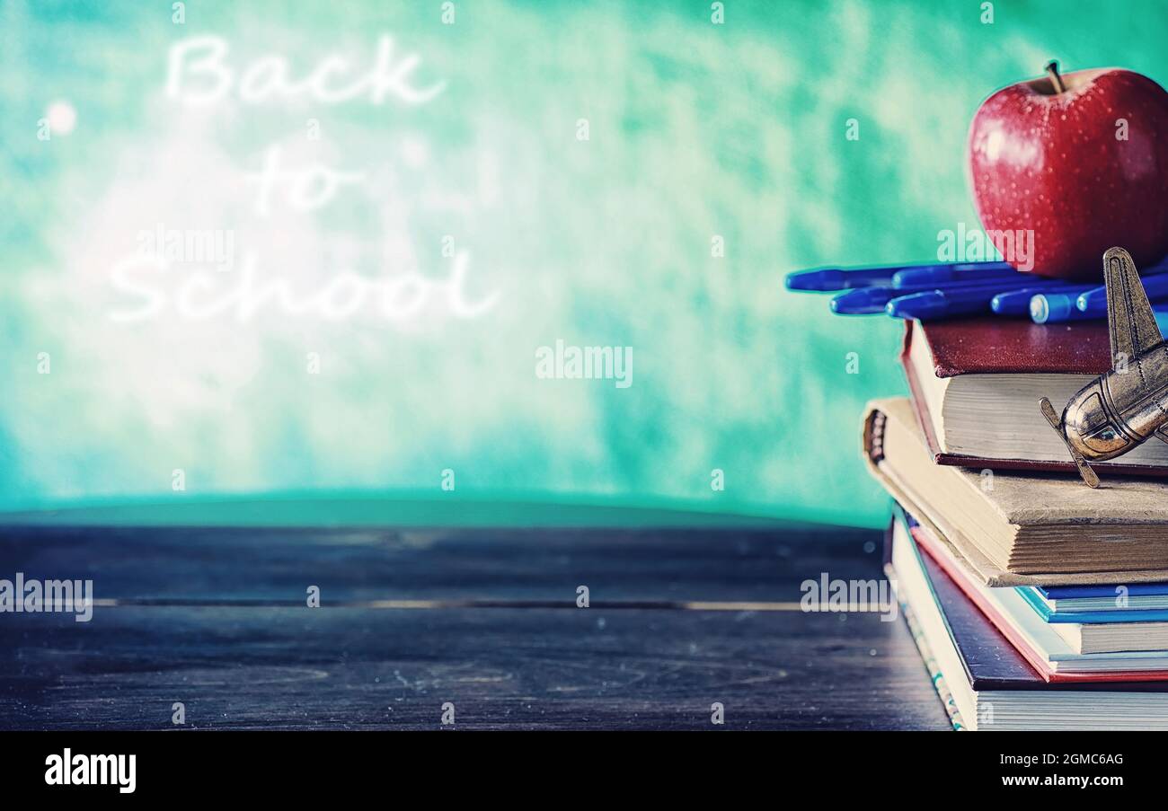 Education concept. A stack of textbooks and a book on the desk with ...