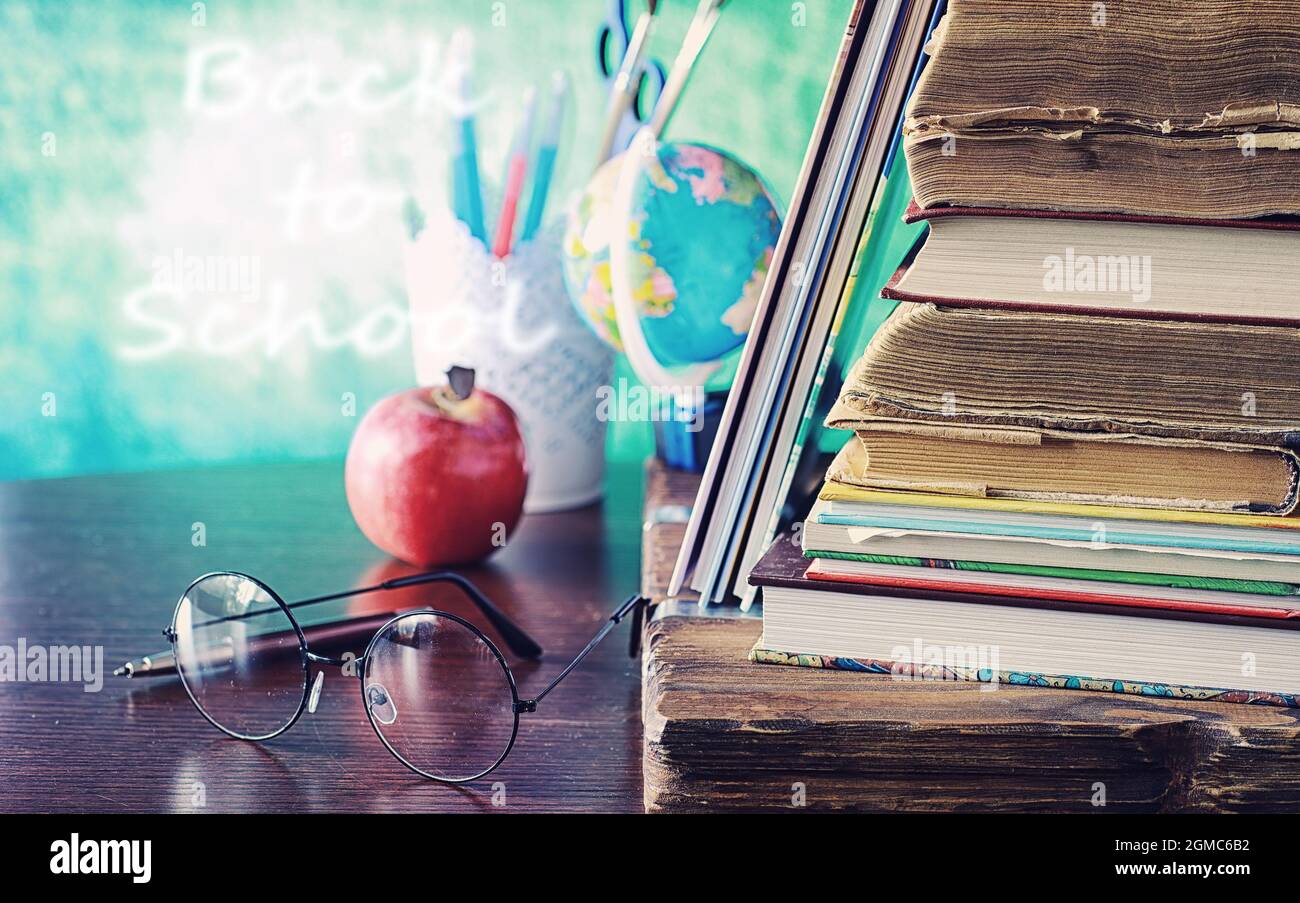 Education concept. A stack of textbooks and a book on the desk with ...