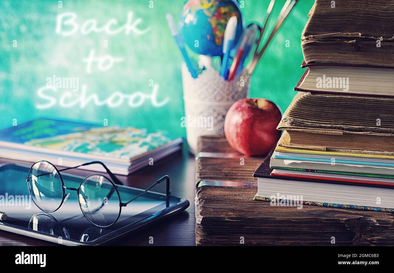 Education concept. A stack of textbooks and a book on the desk with ...