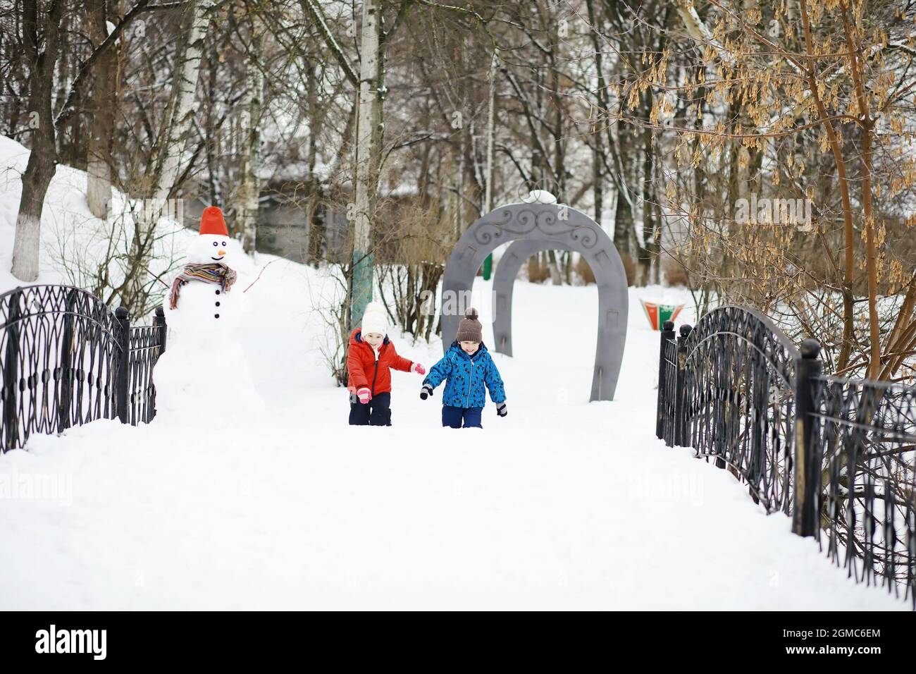 Children in the park in winter. Kids play with snow on the playground ...
